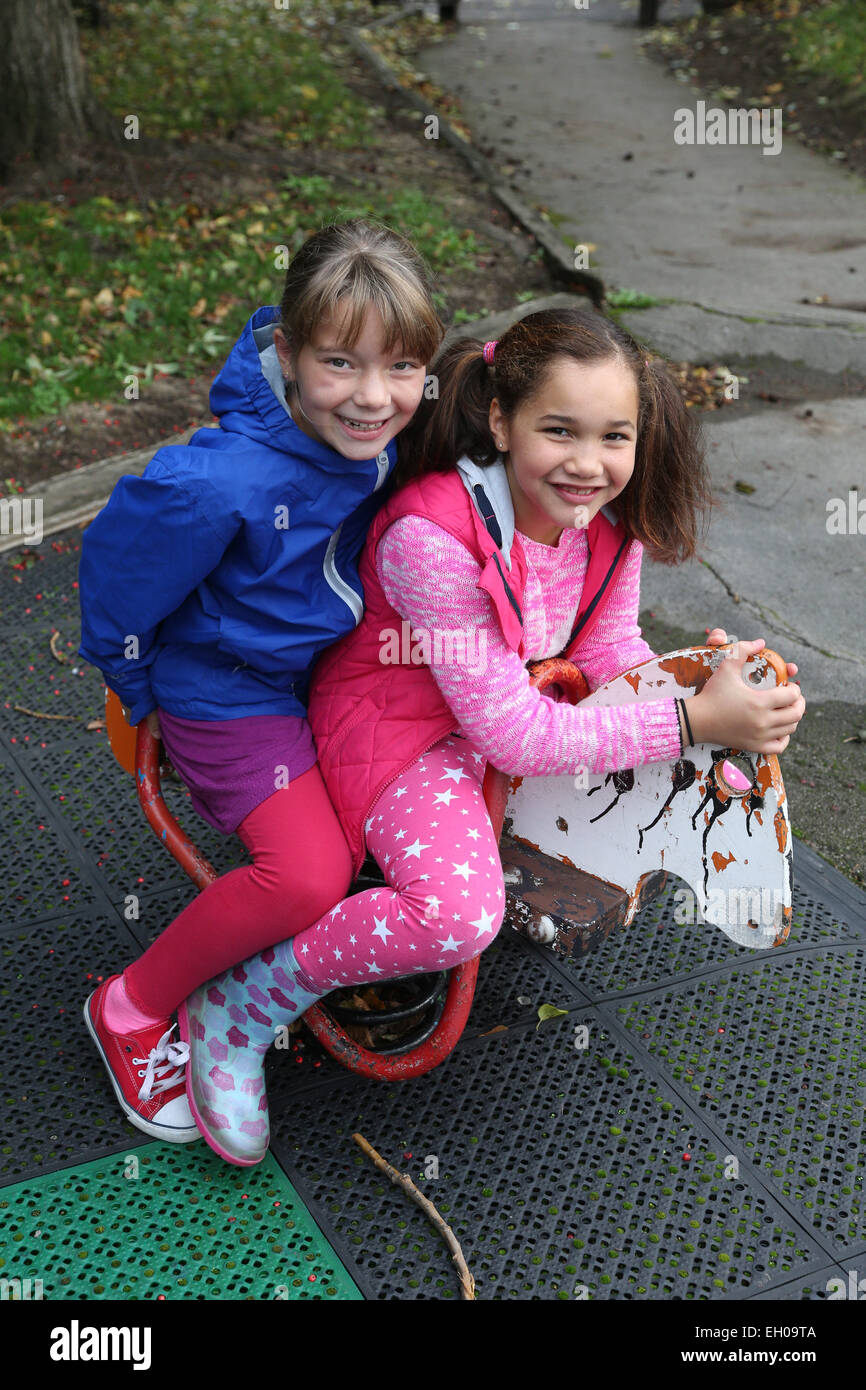 Two girls on rocking horse - model released Stock Photo - Alamy