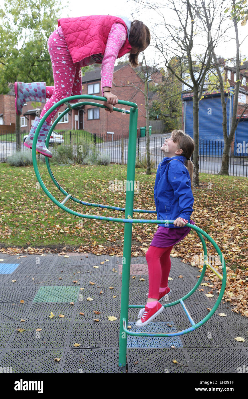 Girls playing in urban park - climbing frame Stock Photo - Alamy