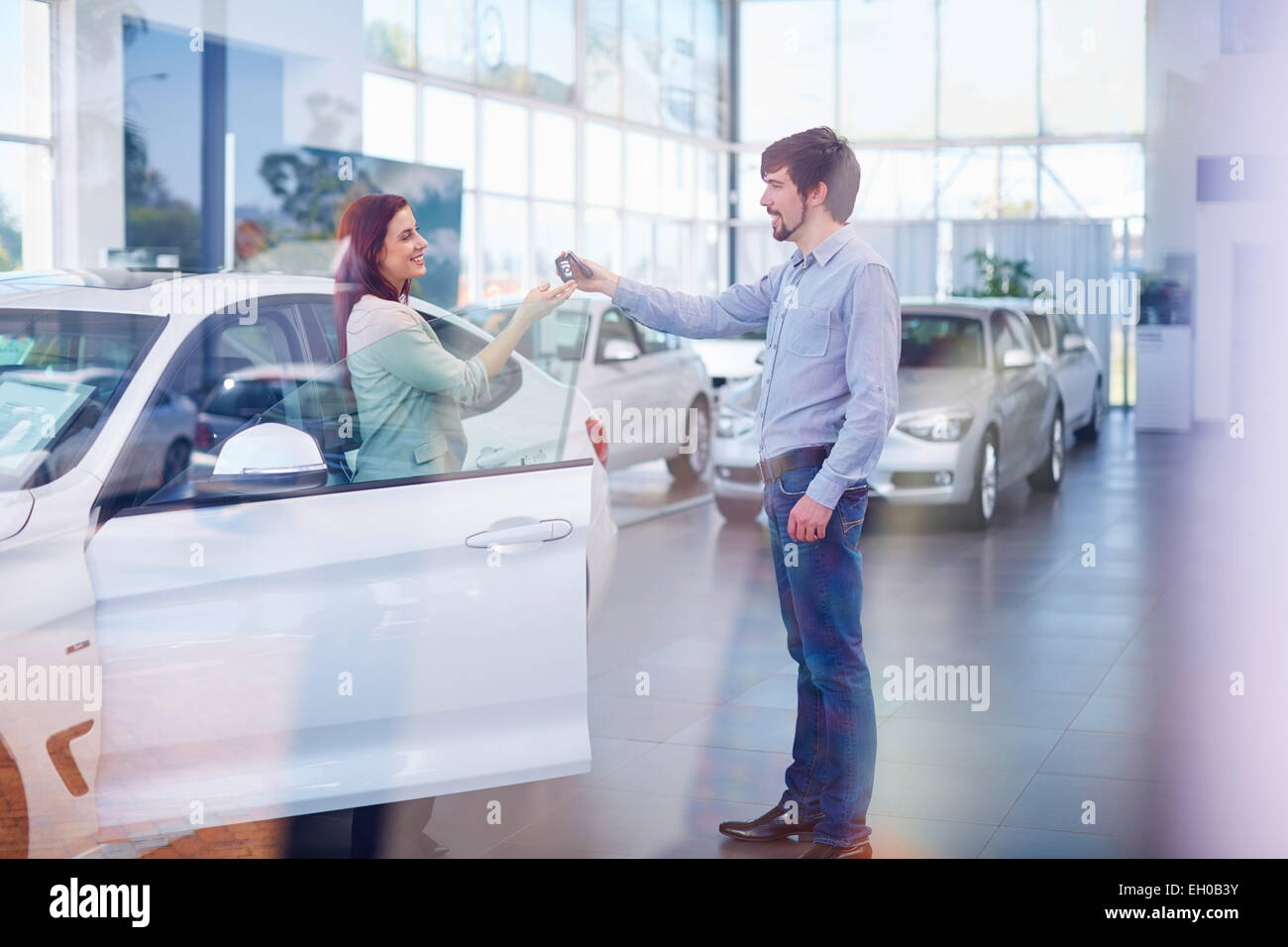 Car dealer giving key to client Stock Photo - Alamy