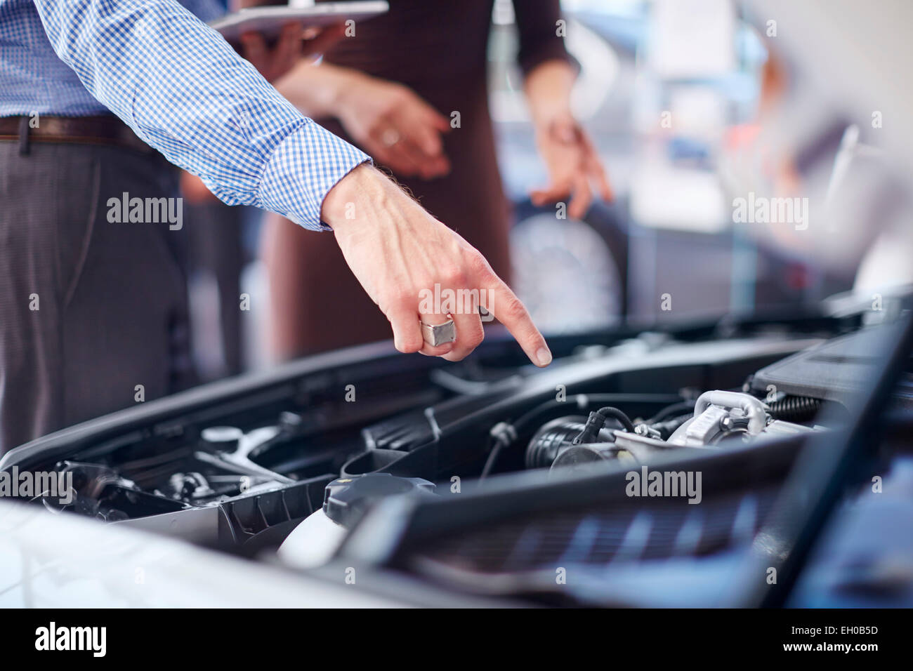 Car dealer explaining car engine Stock Photo - Alamy