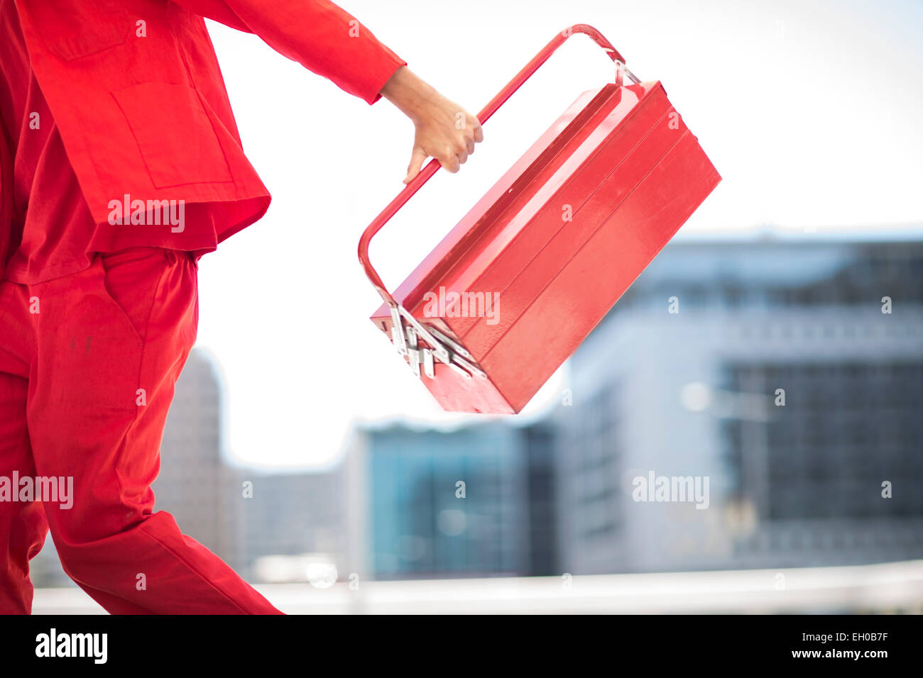 Worker with tool box dressed in red Stock Photo - Alamy