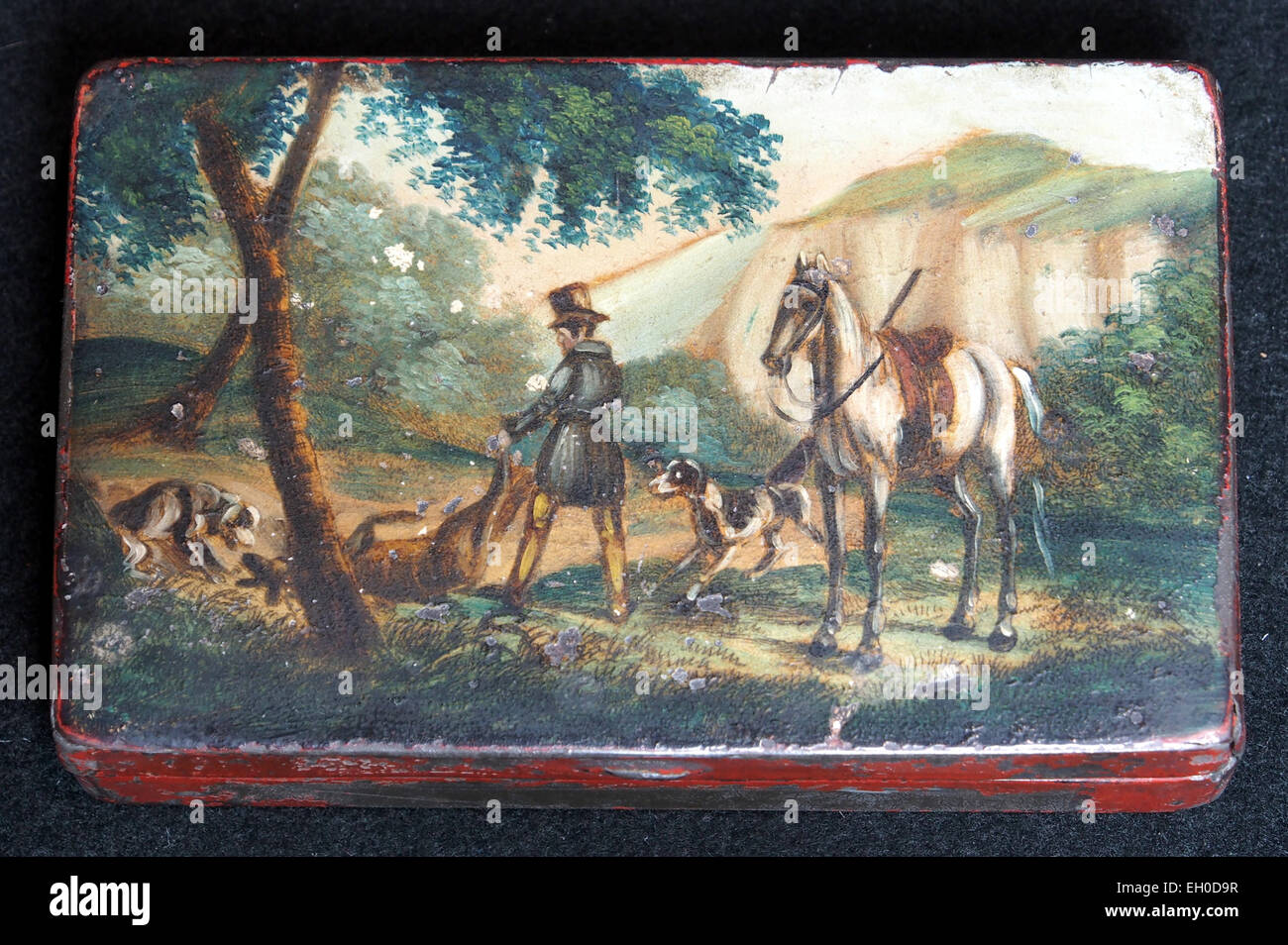 A tin depicting a hunter, likely a vintage or collectible item ...