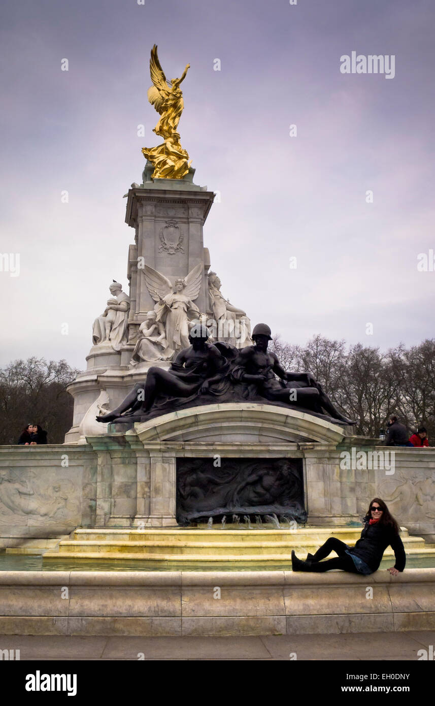 Tourist posing in front of the water feature of the Queen Victoria ...