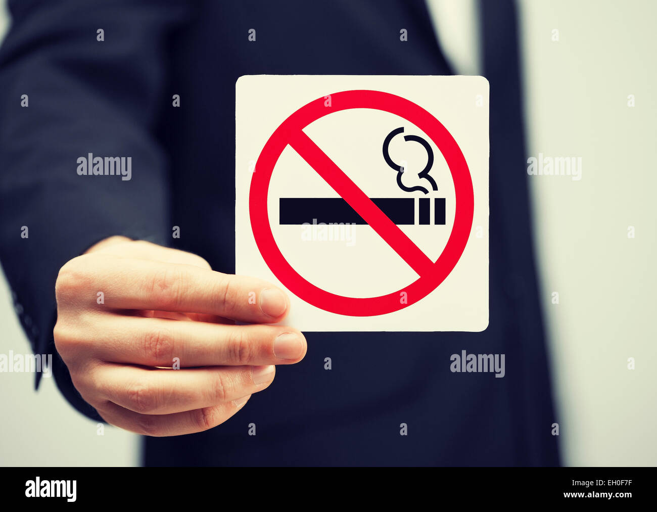 man in suit holding no smoking sign Stock Photo - Alamy
