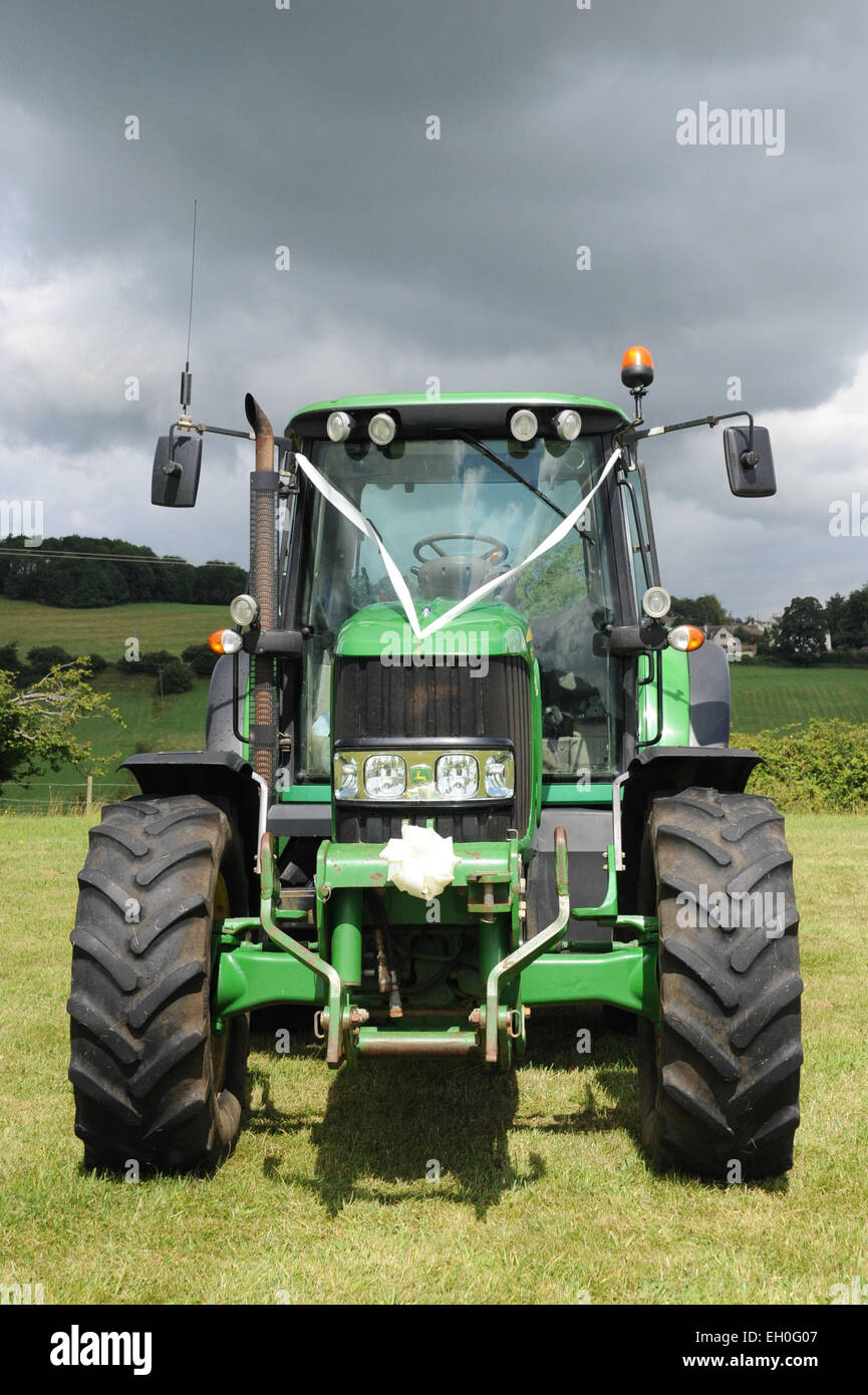 A green tractor decorated with ribbon to carry a bride & groom to ...