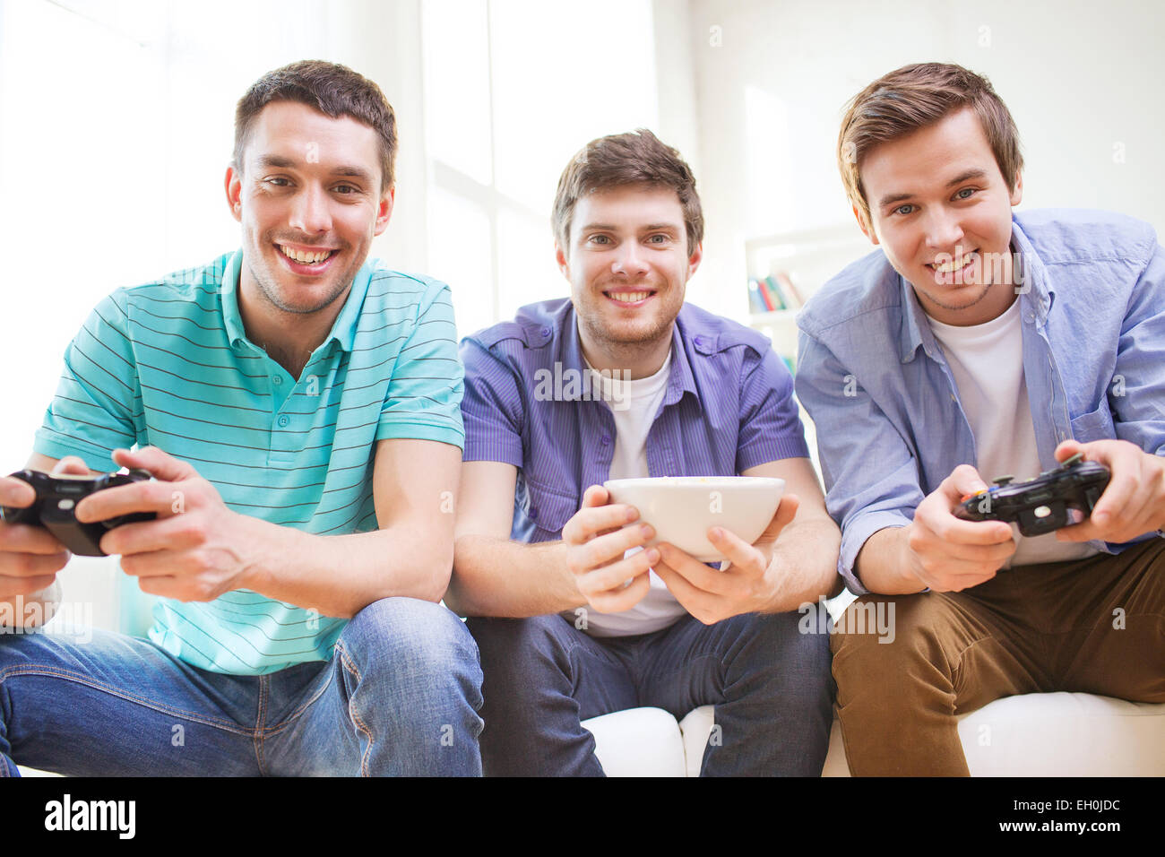 Video game playing friends sofa hi-res stock photography and images - Alamy