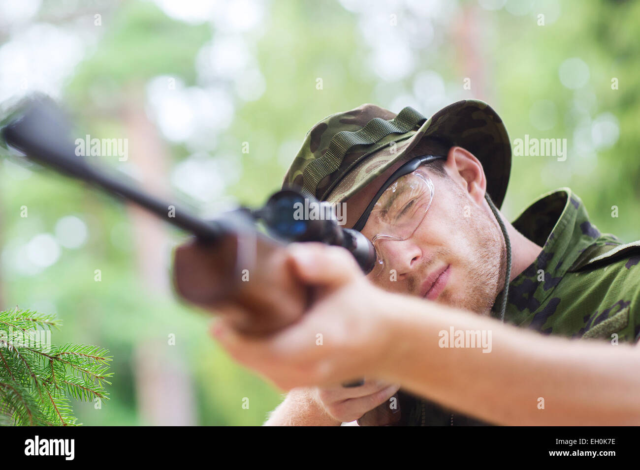young soldier or hunter with gun in forest Stock Photo - Alamy