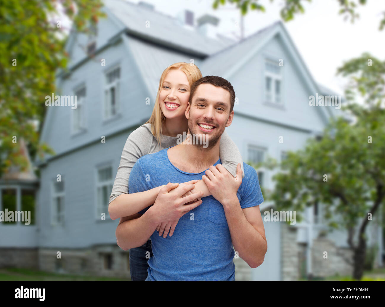 smiling couple hugging over house background Stock Photo - Alamy