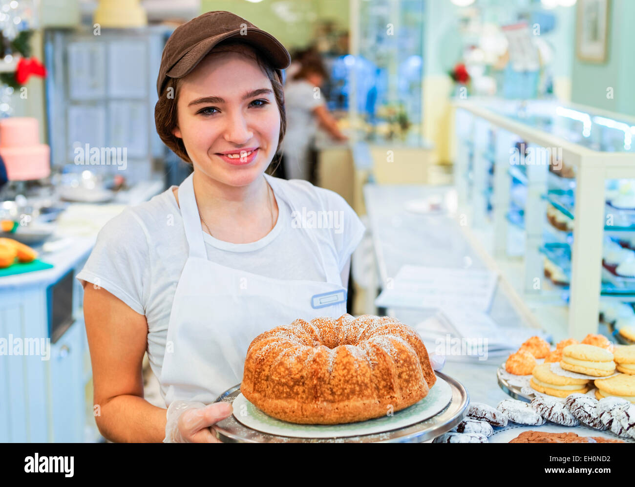 Smiling nice girl with round cake at the bakery Stock Photo - Alamy