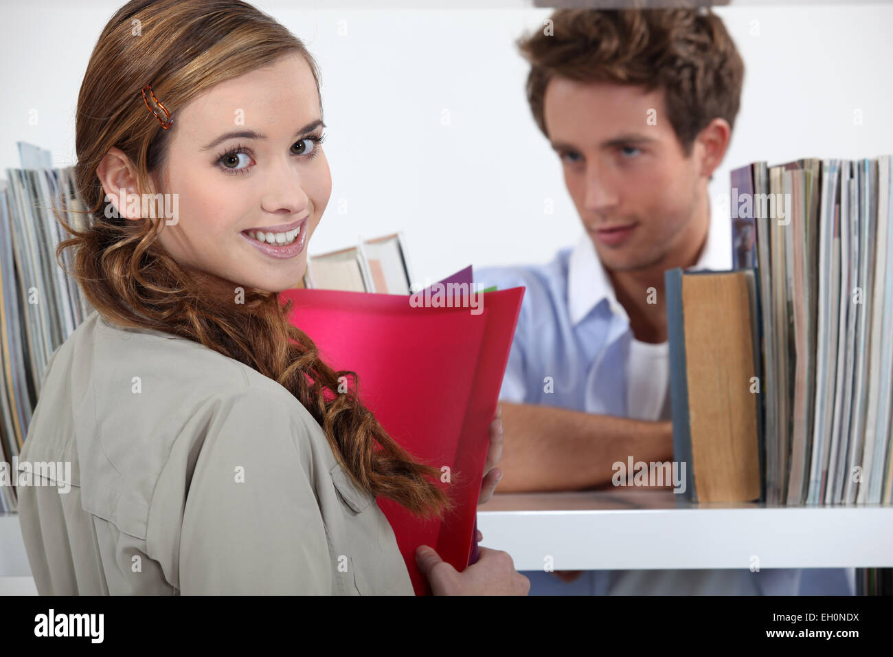 Couple flirting in a library Stock Photo - Alamy