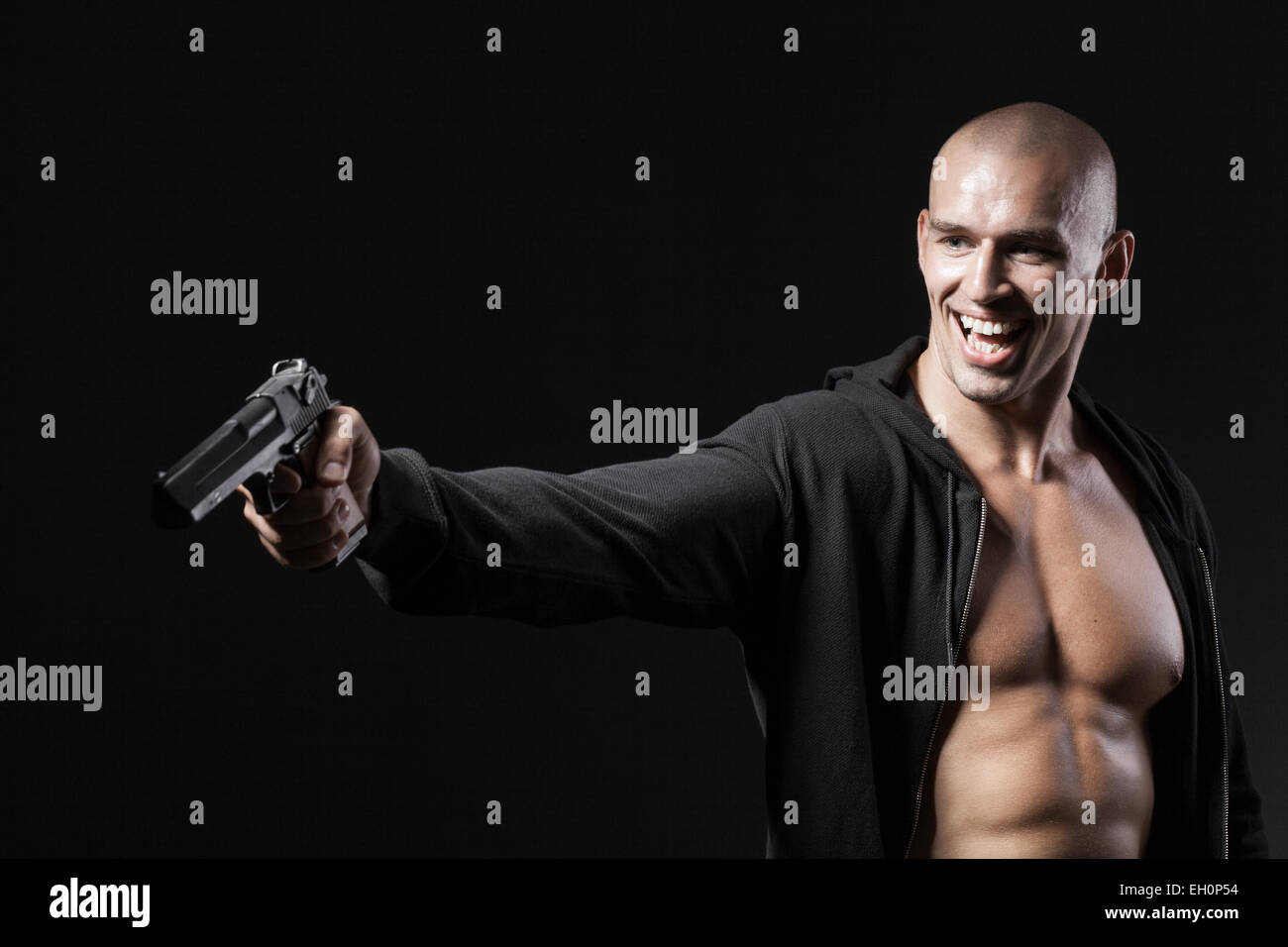 evil smiling man shooting gun isolated on black background Stock Photo ...