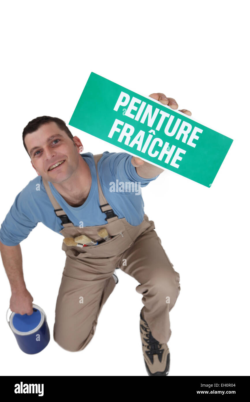 Handyman showing sign for fresh paint Stock Photo - Alamy