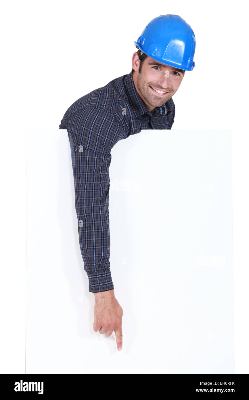 Manual worker pointing downwards at poster Stock Photo - Alamy
