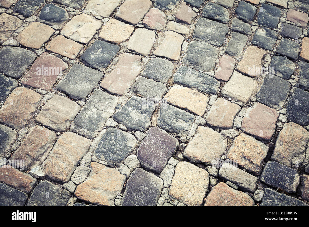 Old stone road pavement, background texture. Vintage toned photo with ...