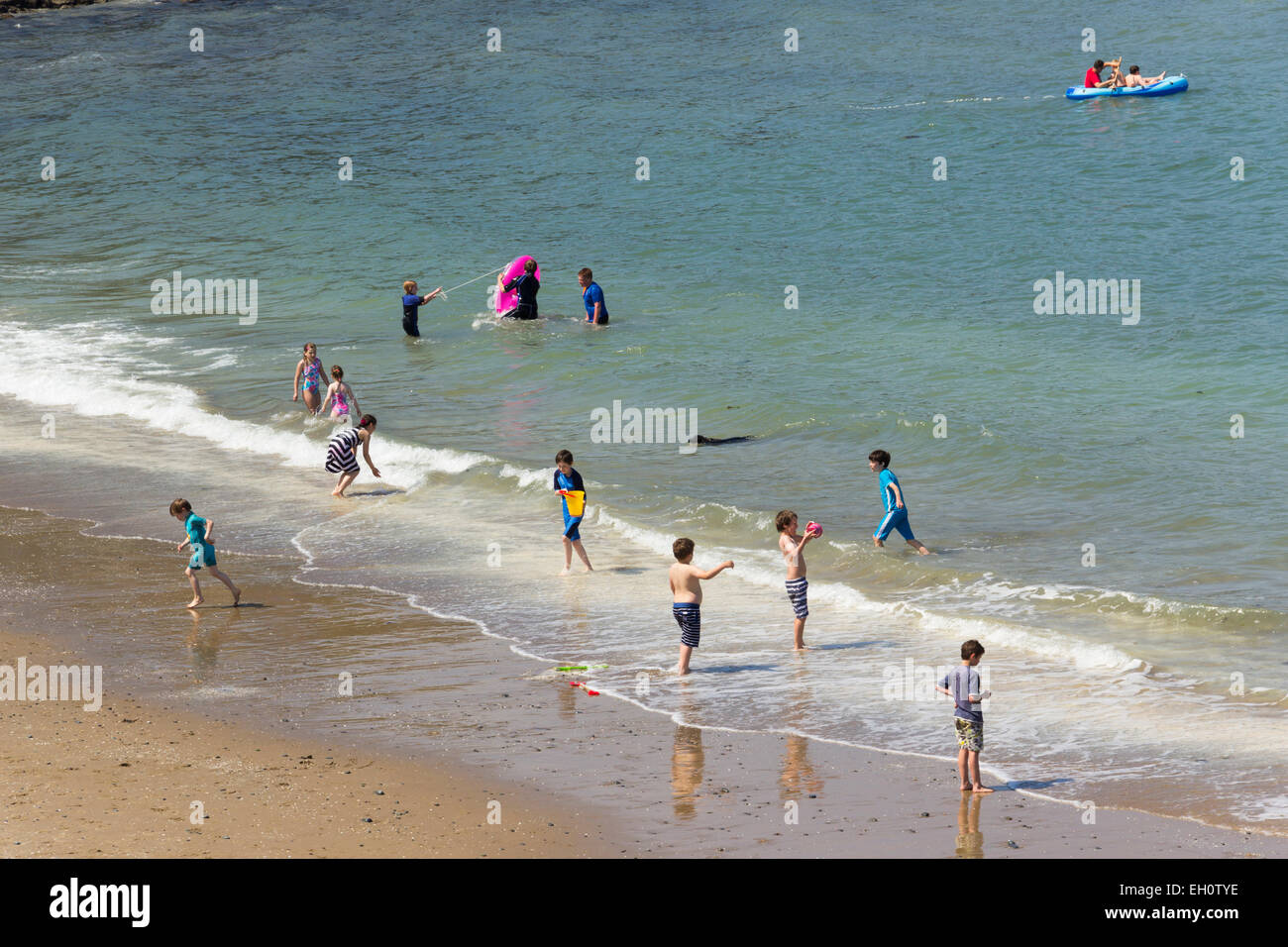 Children paddling on the Traeth Y Dolau beach at New Quay, Ceredigion ...