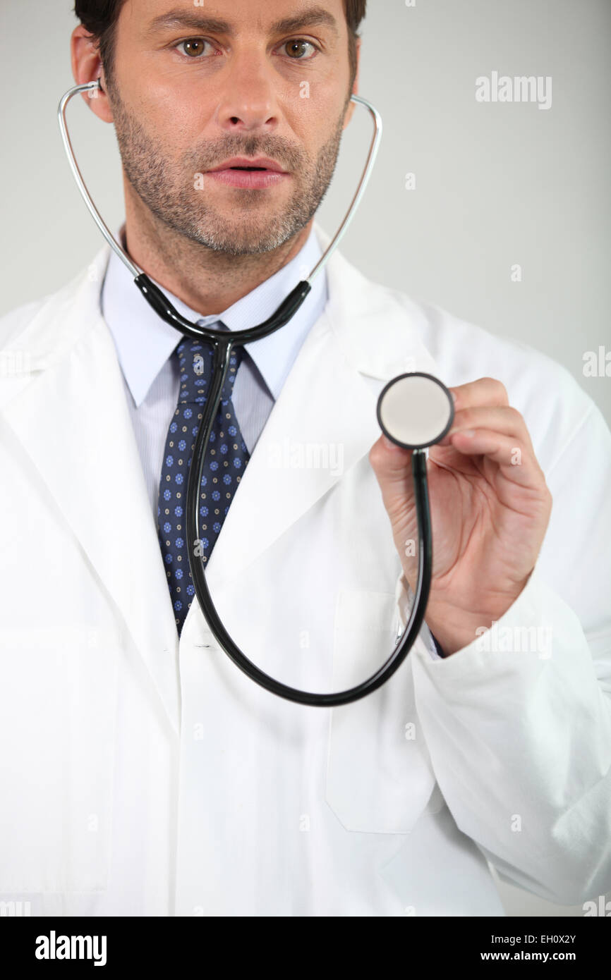 Doctor listening through stethoscope hi-res stock photography and ...
