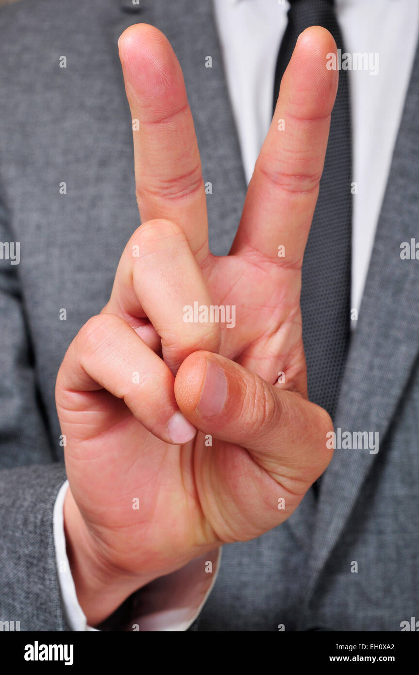 a man wearing a suit giving the V sign as symbol of success Stock Photo ...