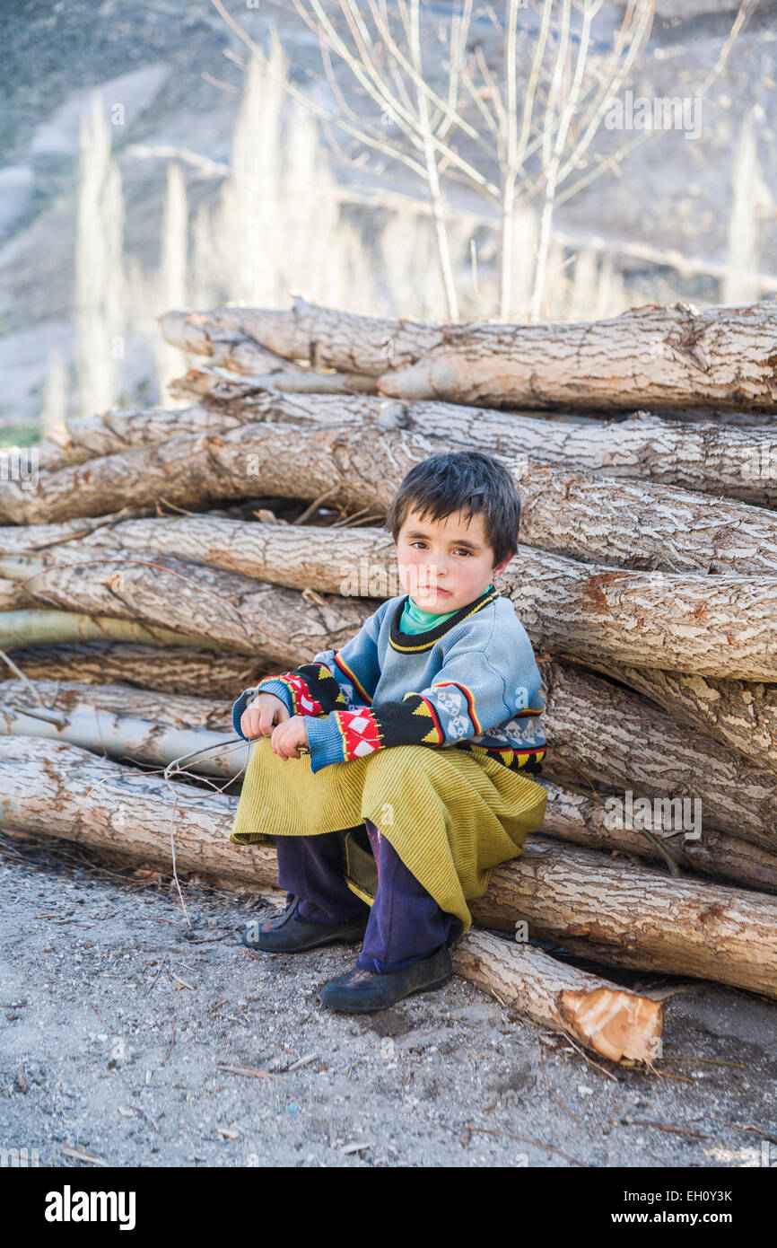 Cute young Turkish boy dressed in local style clothes sitting on a pile ...