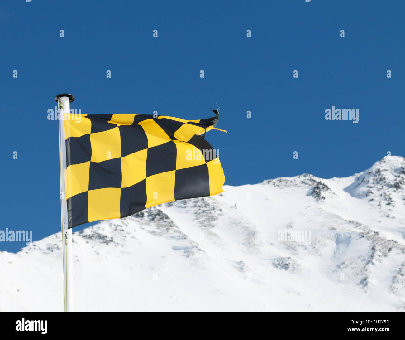 Yellow and black avalanche danger high risk warning flag flying in the ...