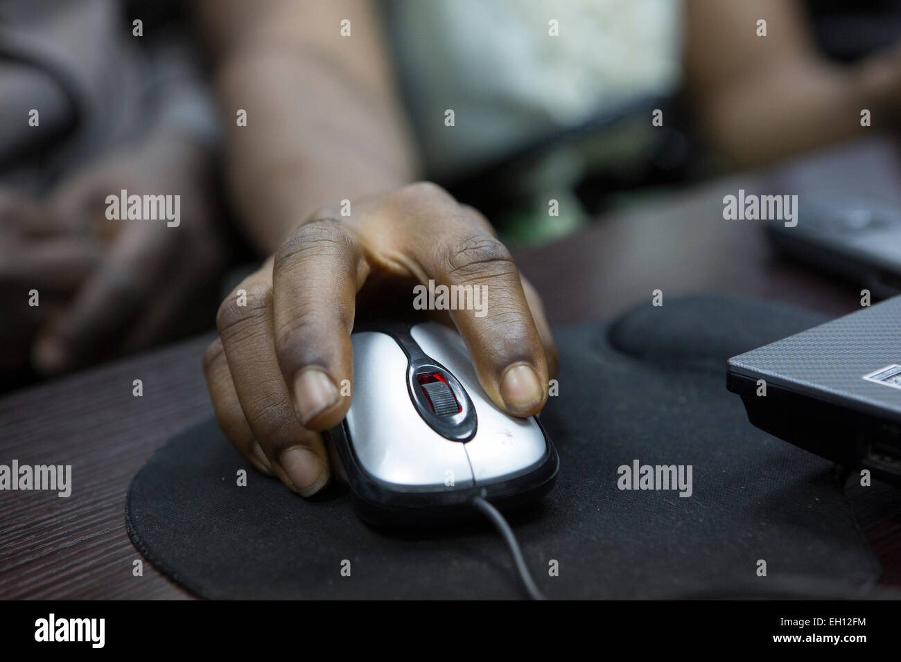 Lagos, Nigeria; Using a mouse with a laptop computer in a city office ...