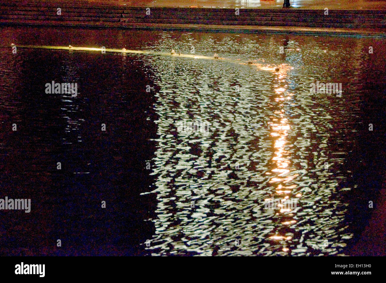 A fountain pool at night with interesting reflections Stock Photo - Alamy