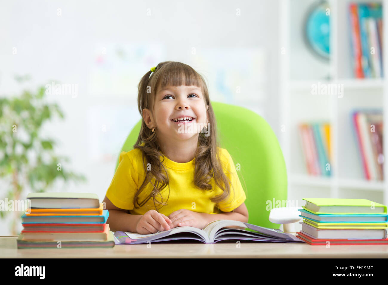 smiling child girl reading book at home Stock Photo - Alamy