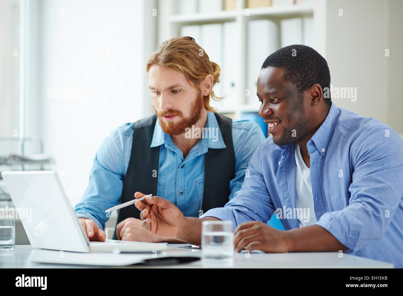 Two men discussing laptop presentation in office Stock Photo - Alamy