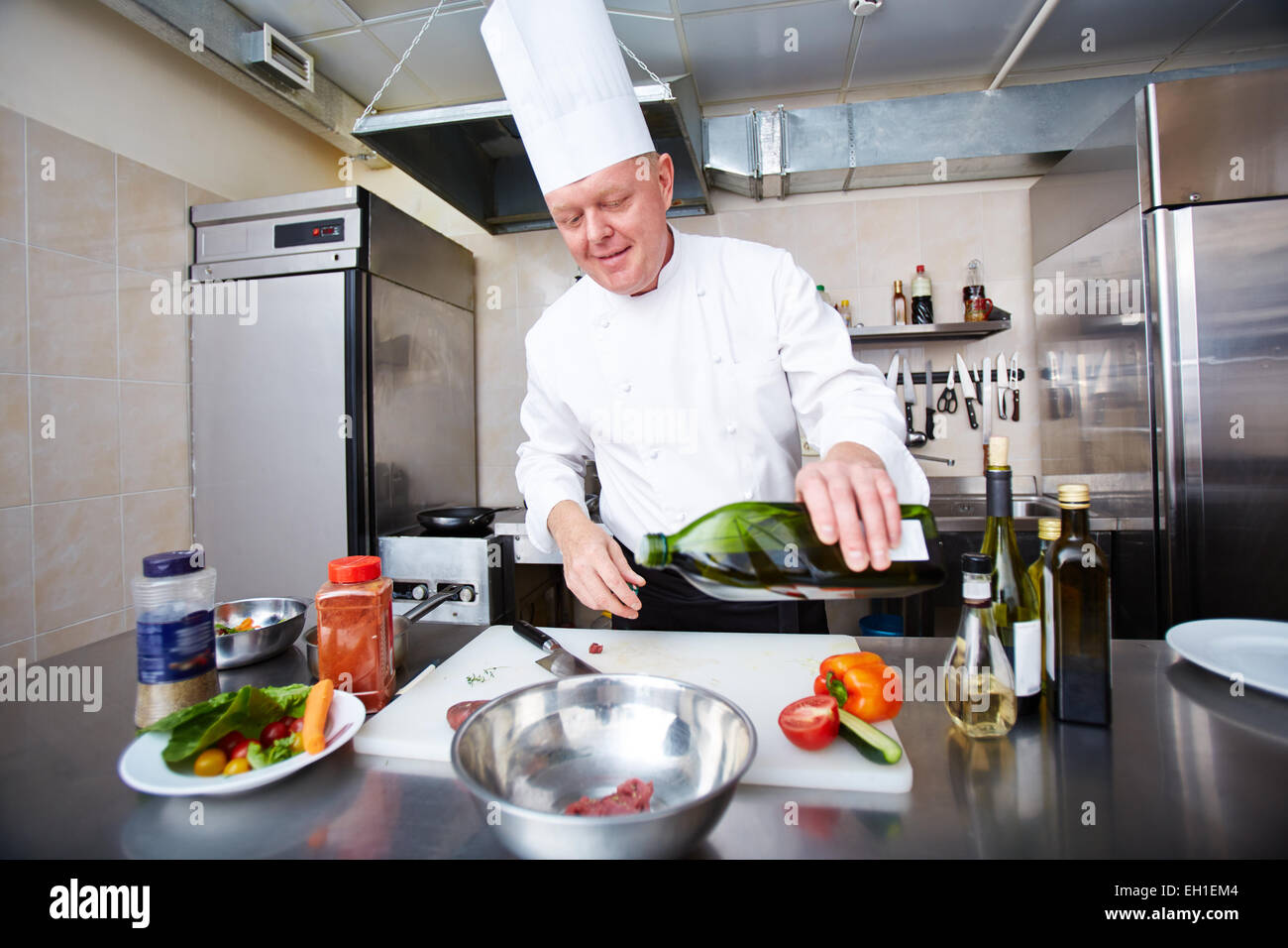 Chef adding oil at his dish Stock Photo - Alamy