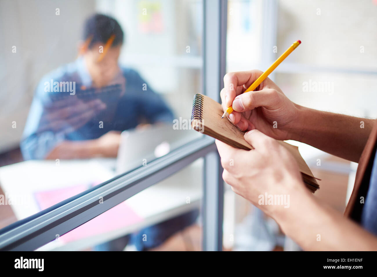 Hands of employee making notes in notepad Stock Photo - Alamy