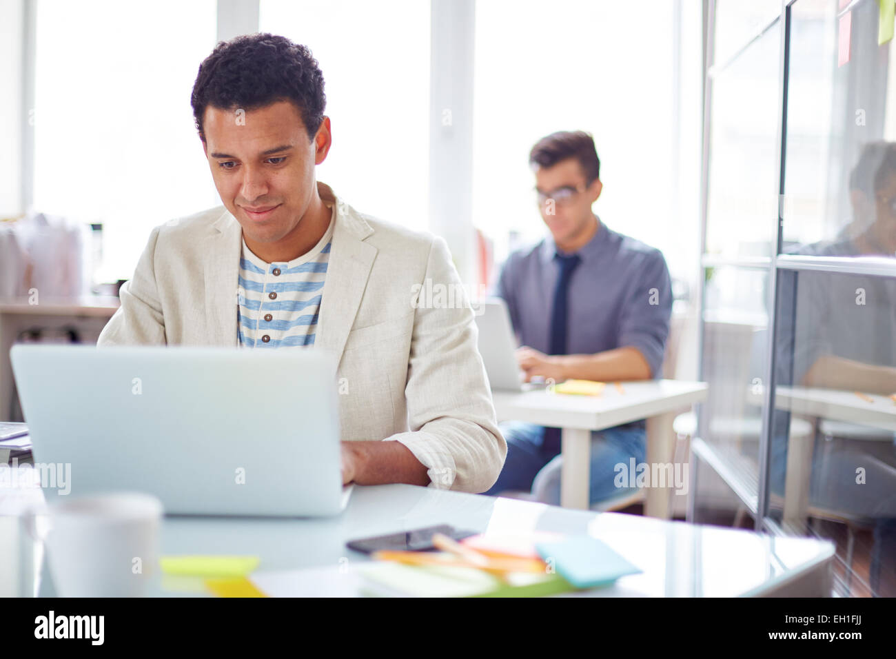 Successful young employee networking in office environment Stock Photo ...