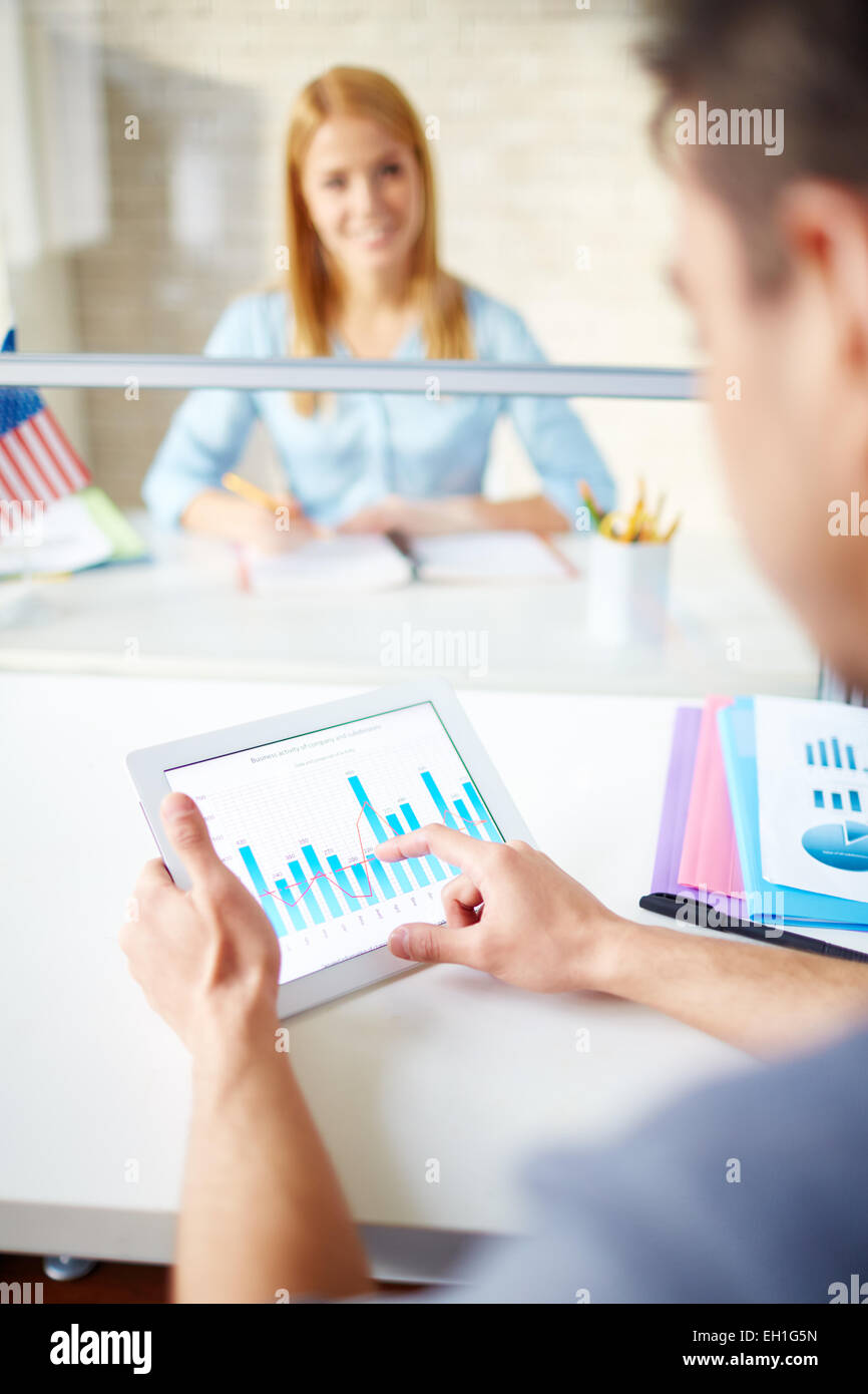 Young businessman using touchpad on background of female Stock Photo ...