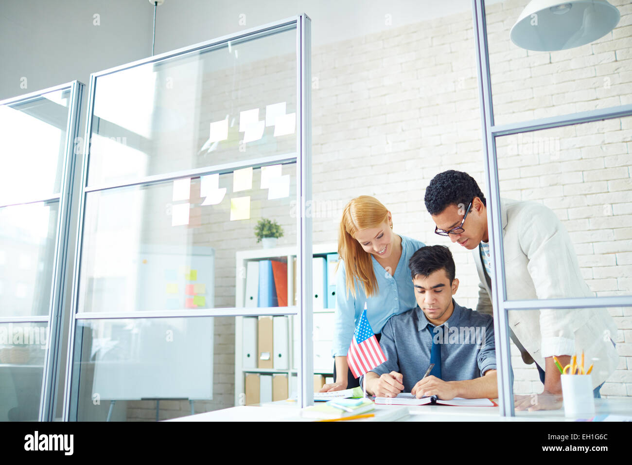 Young businessman signing paper with his colleagues near by Stock Photo ...