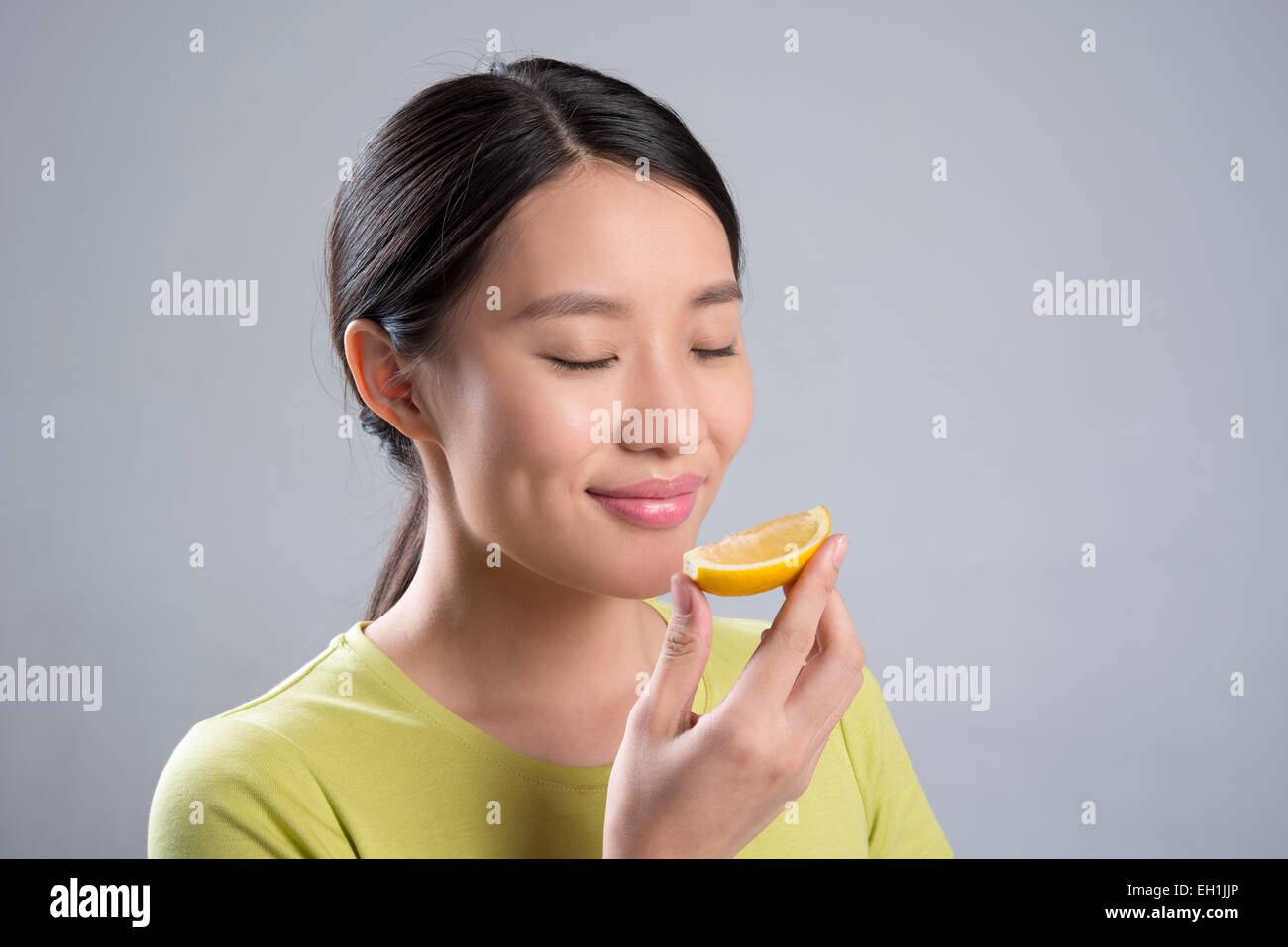 Young woman eating lemon Stock Photo - Alamy