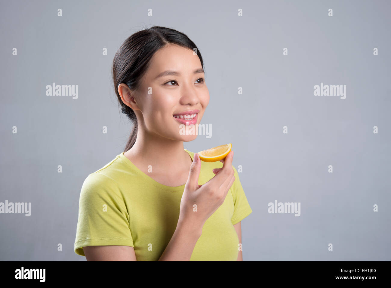 Young woman eating lemon Stock Photo - Alamy