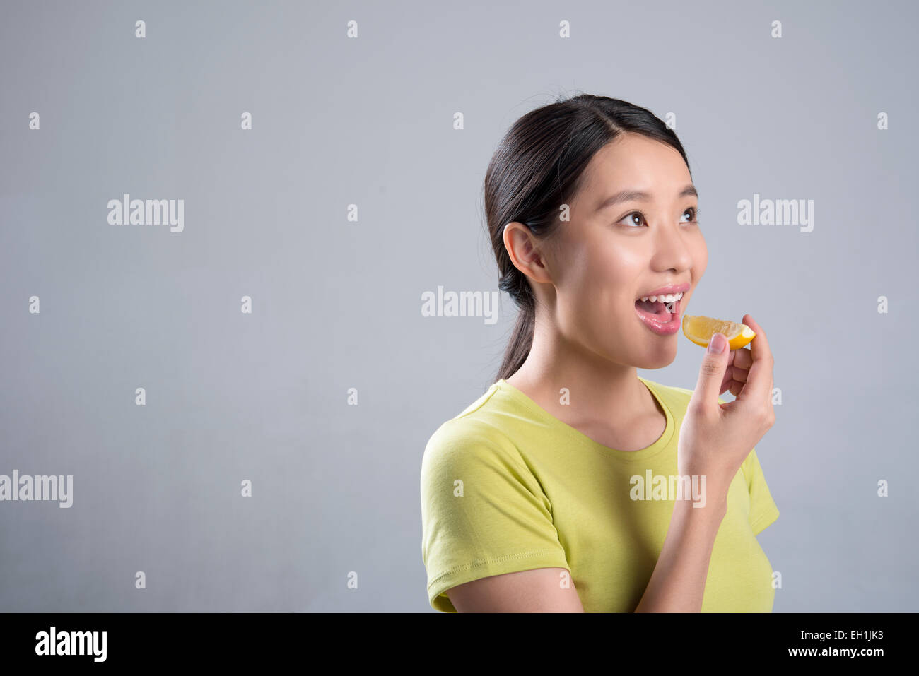 Young woman eating lemon Stock Photo - Alamy