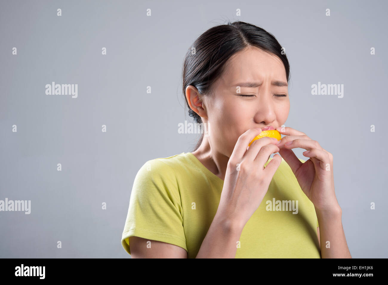 Young woman eating lemon Stock Photo - Alamy