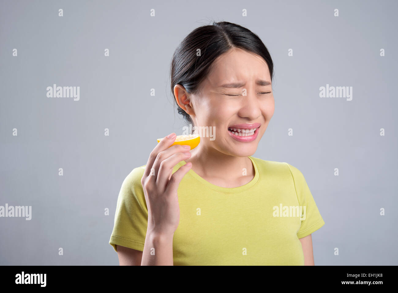 Young woman eating lemon Stock Photo - Alamy
