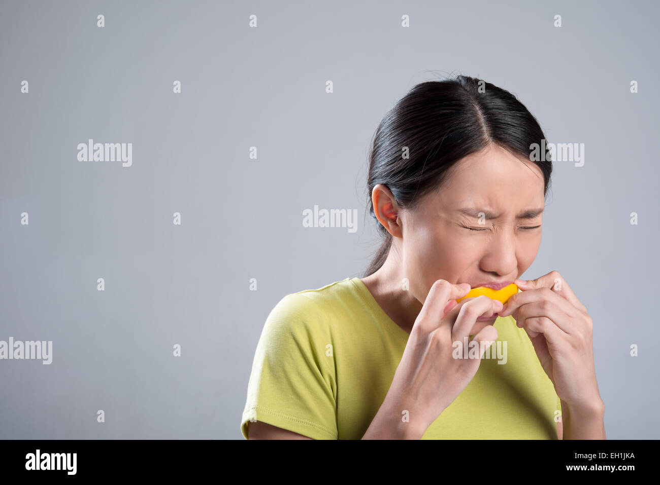 Young woman eating lemon Stock Photo - Alamy