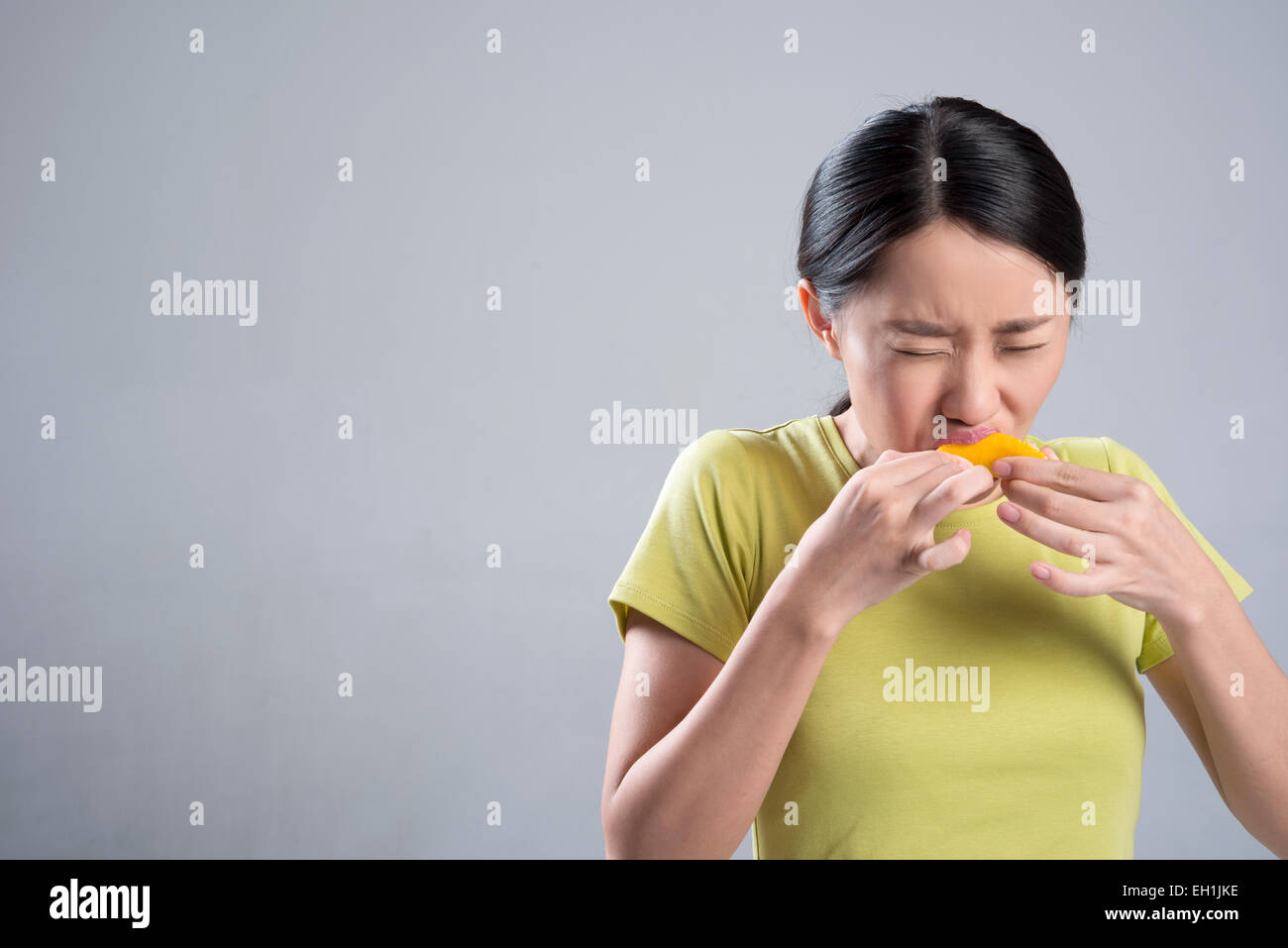 Young woman eating lemon Stock Photo - Alamy