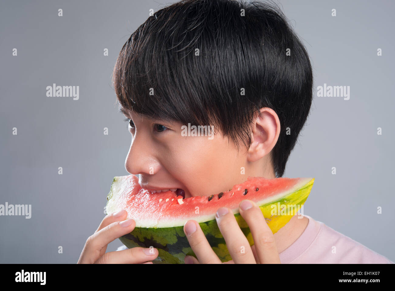 Young man eating watermelon Stock Photo - Alamy