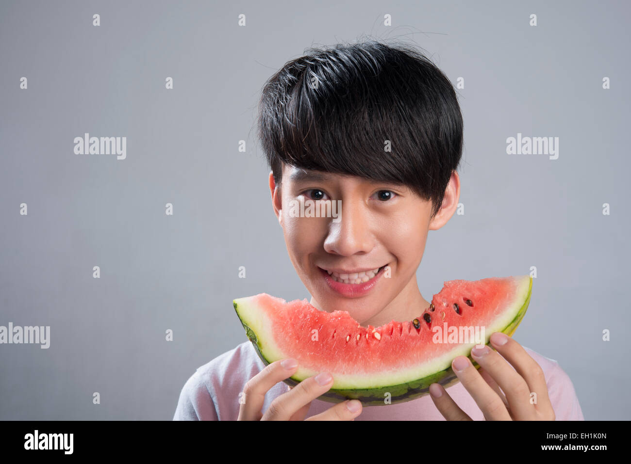 Young man eating watermelon Stock Photo - Alamy