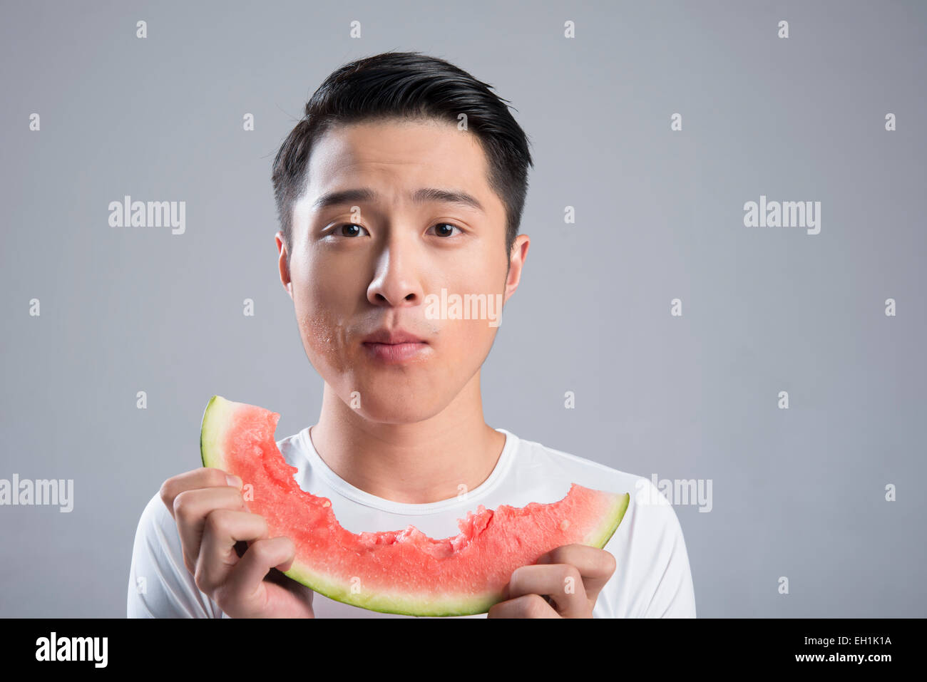 Young man eating watermelon Stock Photo - Alamy