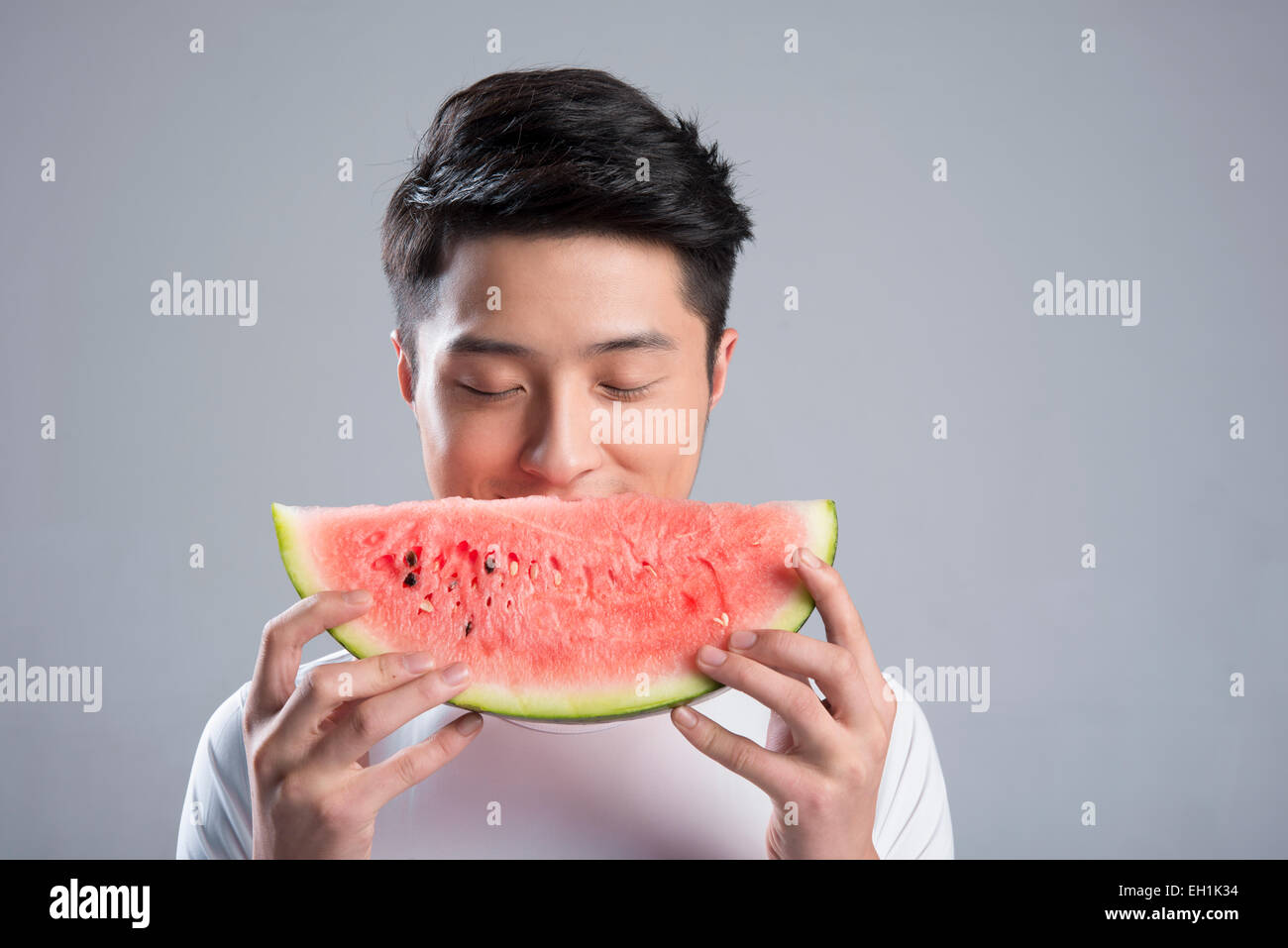 Young man eating watermelon Stock Photo - Alamy