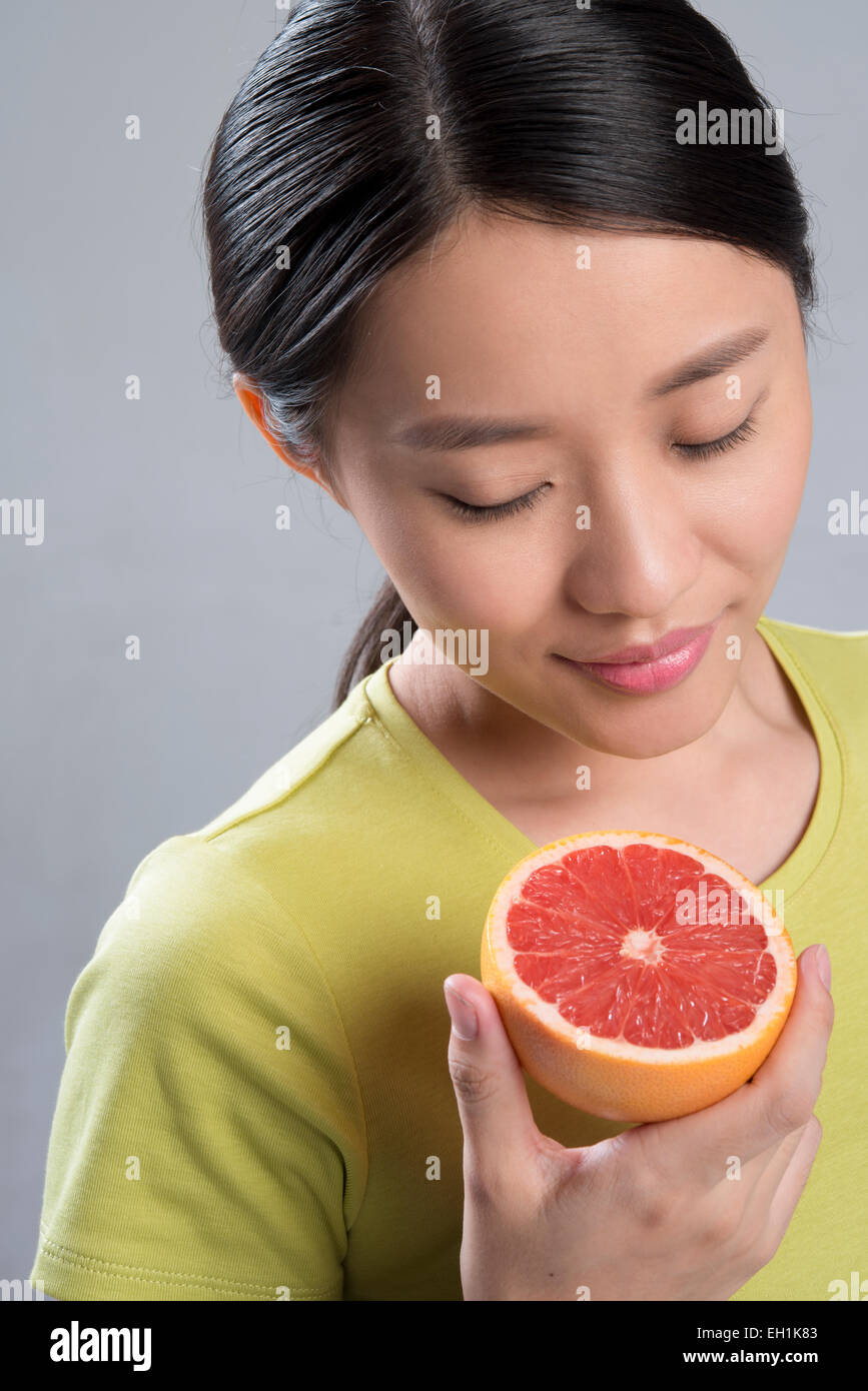 Young woman eating grapefruit Stock Photo - Alamy