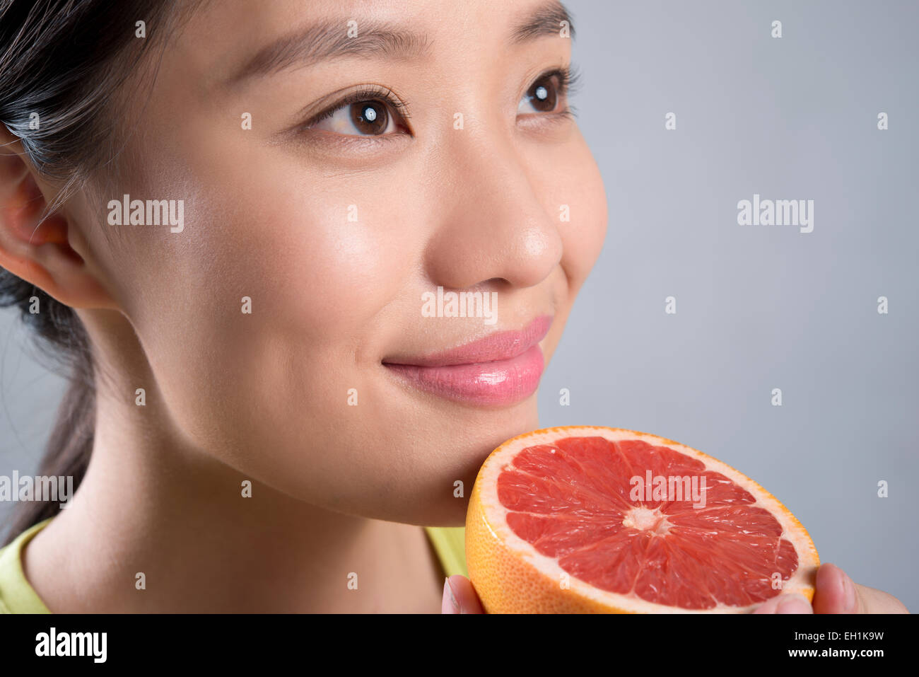 Young woman eating grapefruit Stock Photo - Alamy
