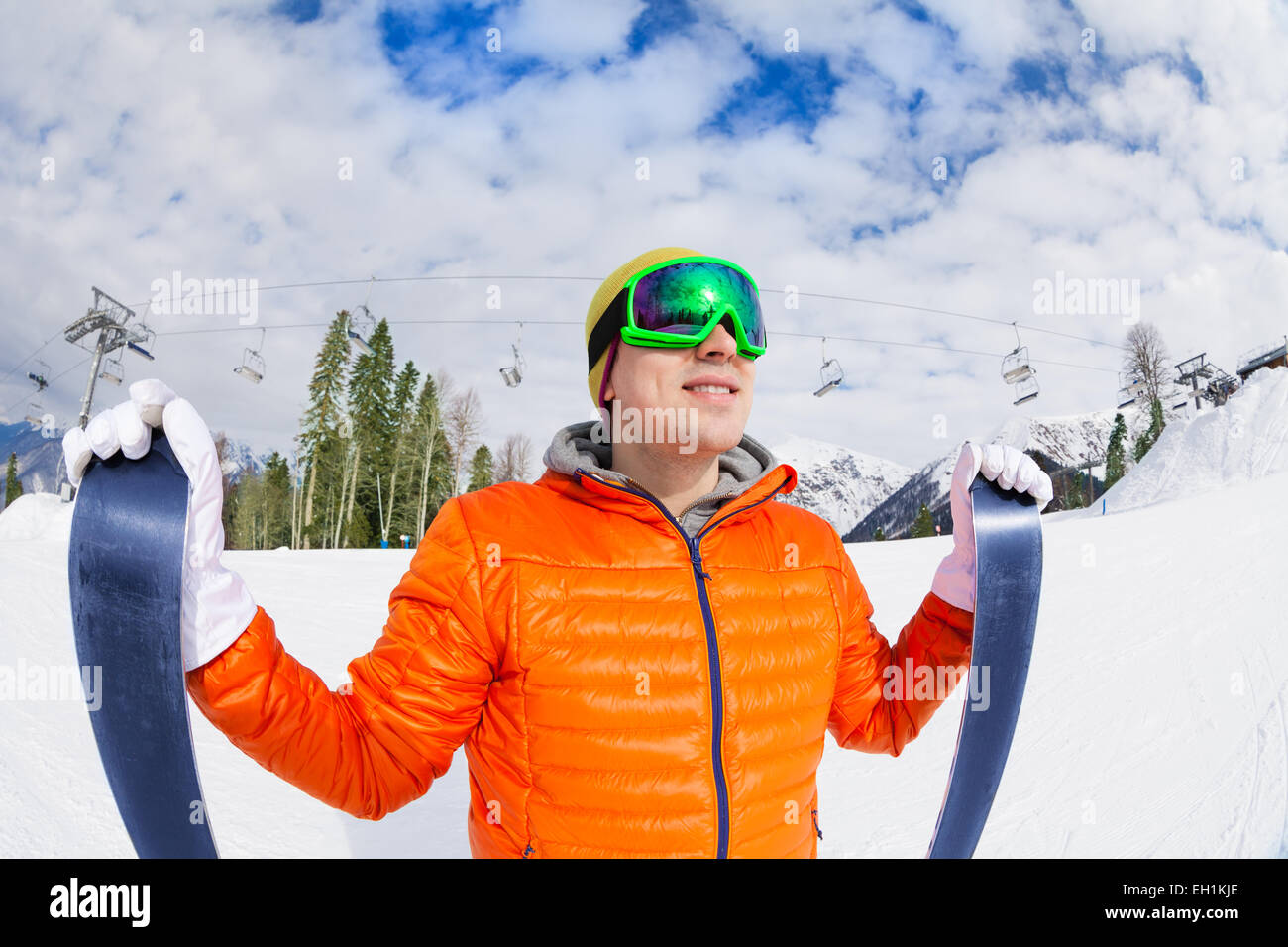 Smiling guy wearing mask holding ski in winter Stock Photo - Alamy
