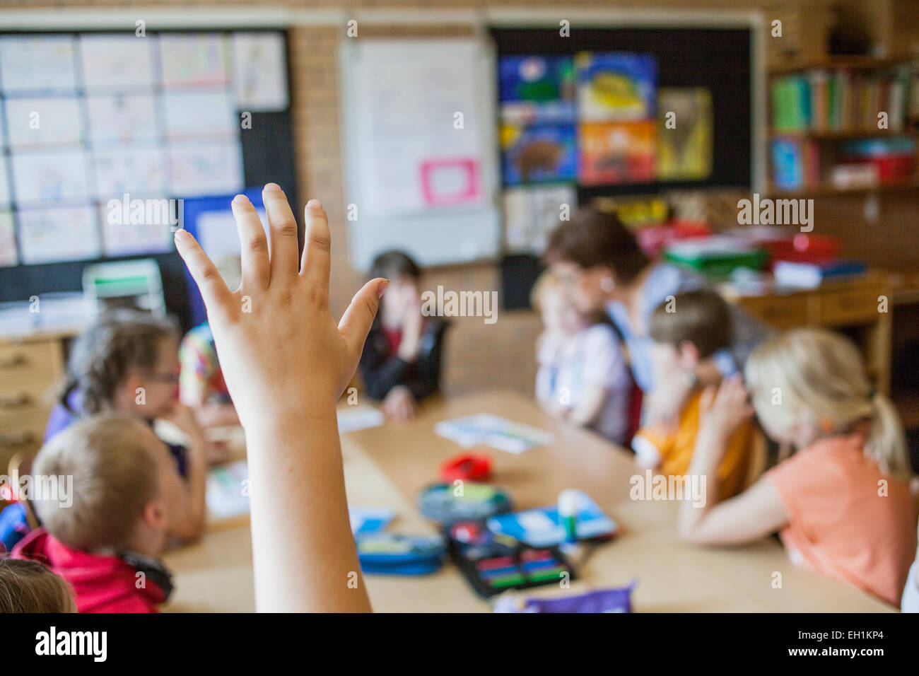 Boy raising hand in classroom hi-res stock photography and images - Alamy
