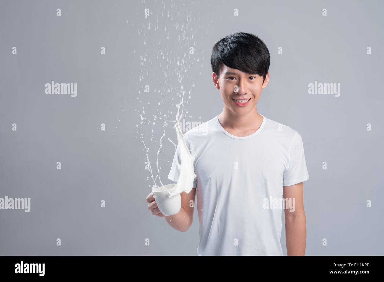 Young man with splashing milk Stock Photo - Alamy