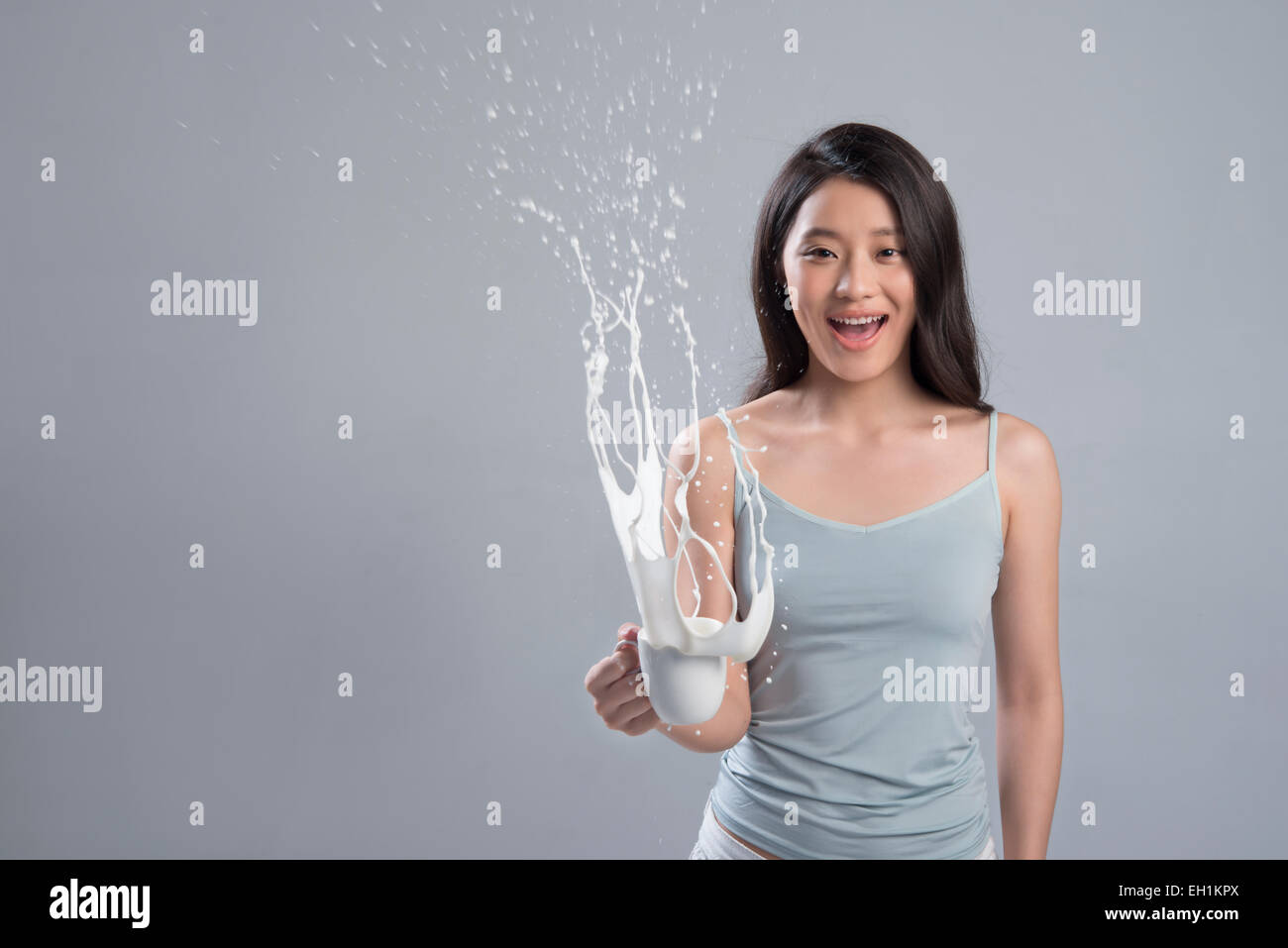 Young woman with splashing milk Stock Photo - Alamy