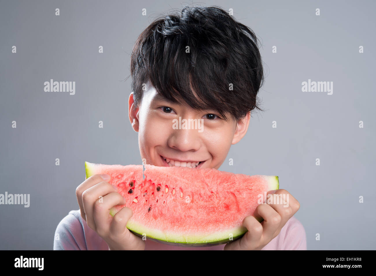 Young man eating watermelon Stock Photo - Alamy